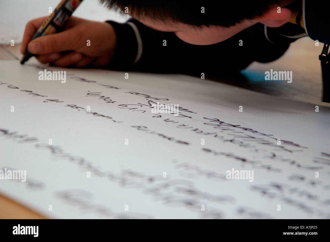 Young child writing in class at school Stock Photo - Alamy