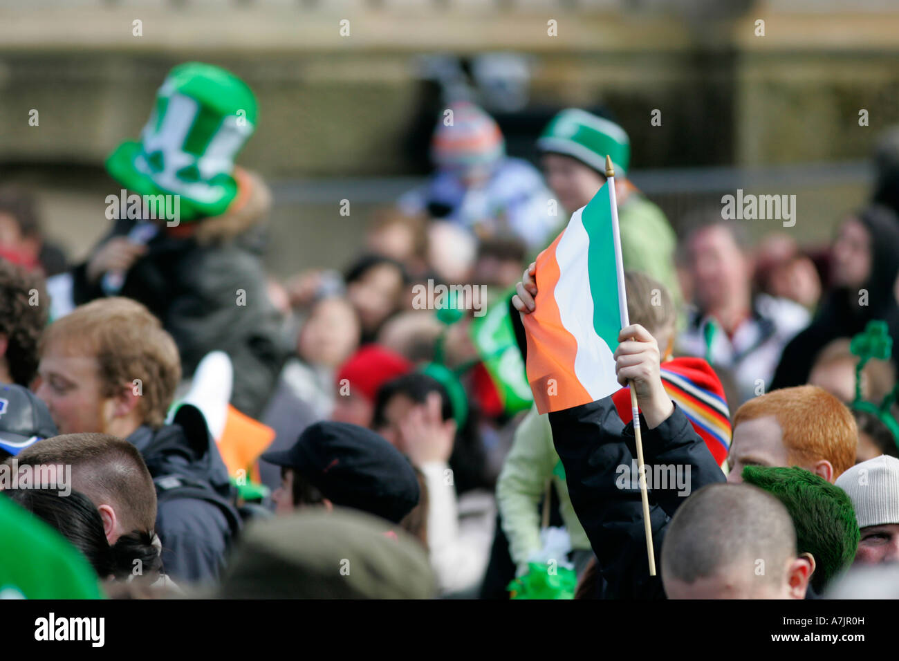 boy holding green white and orange irish tricolour flag in the crowd at ...