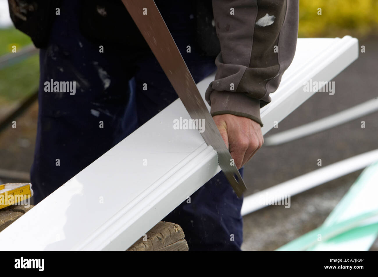 workman sawing finely through pvc panel during installation white pvc ...