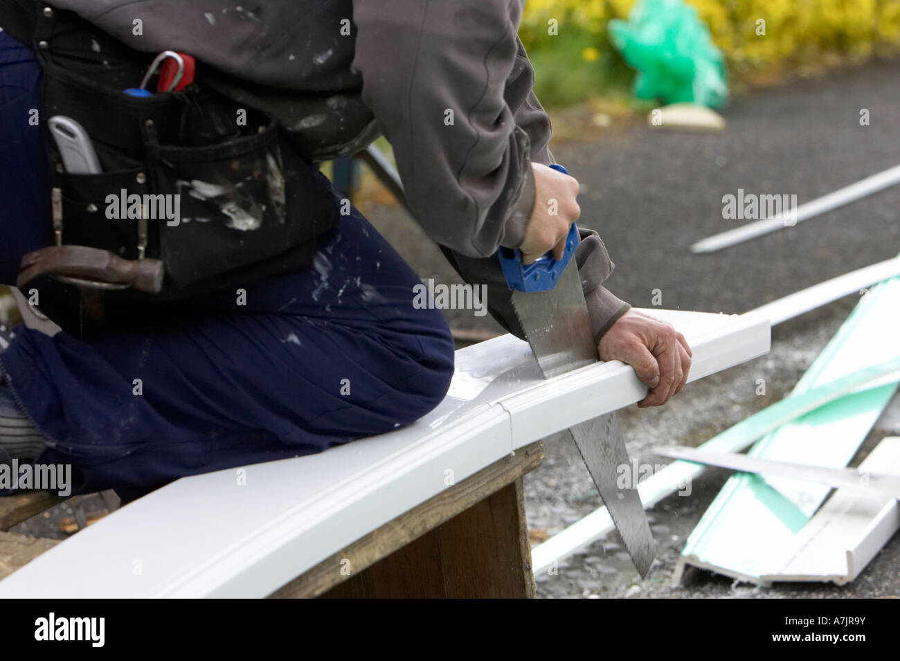 workman sawing through pvc panel lengthwise during installation white ...