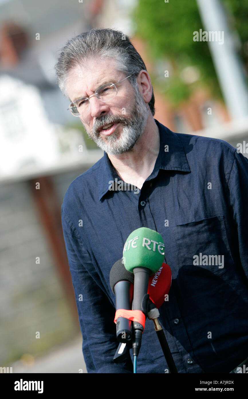 angled shot of Gerry Adams speaking and microphones at a street press ...