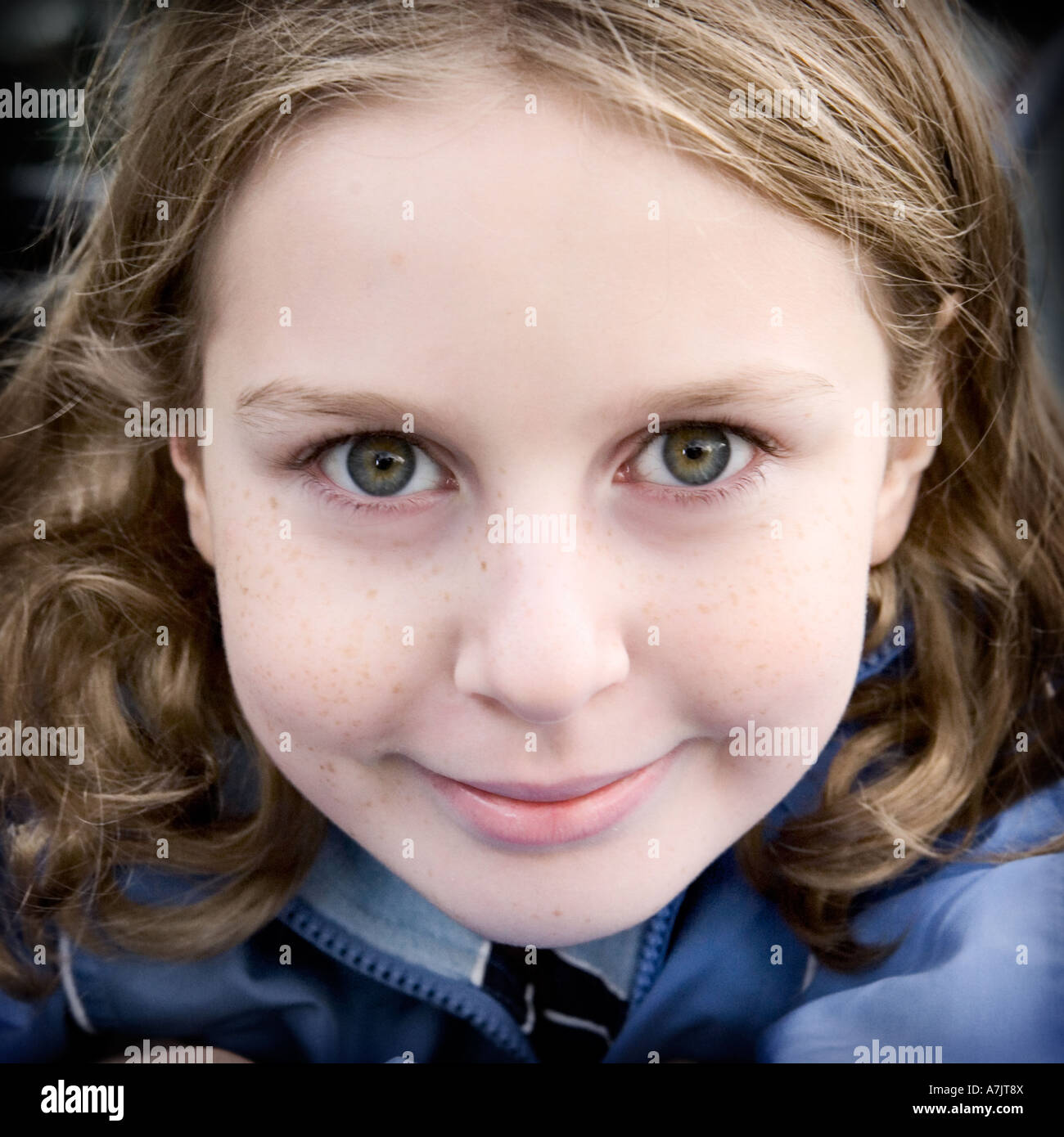 square portrait of young blonde green eyed girl staring into camera ...