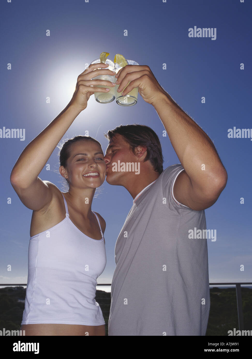 Low angle view of a young couple toasting with drinks Stock Photo - Alamy