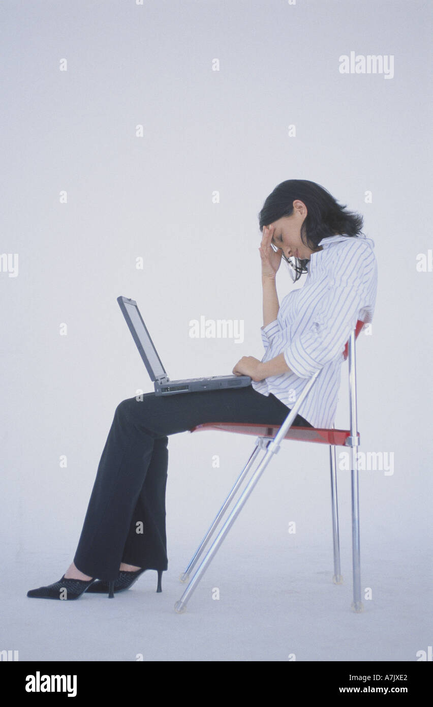 Side profile of a young woman sitting on a chair with a laptop Stock ...