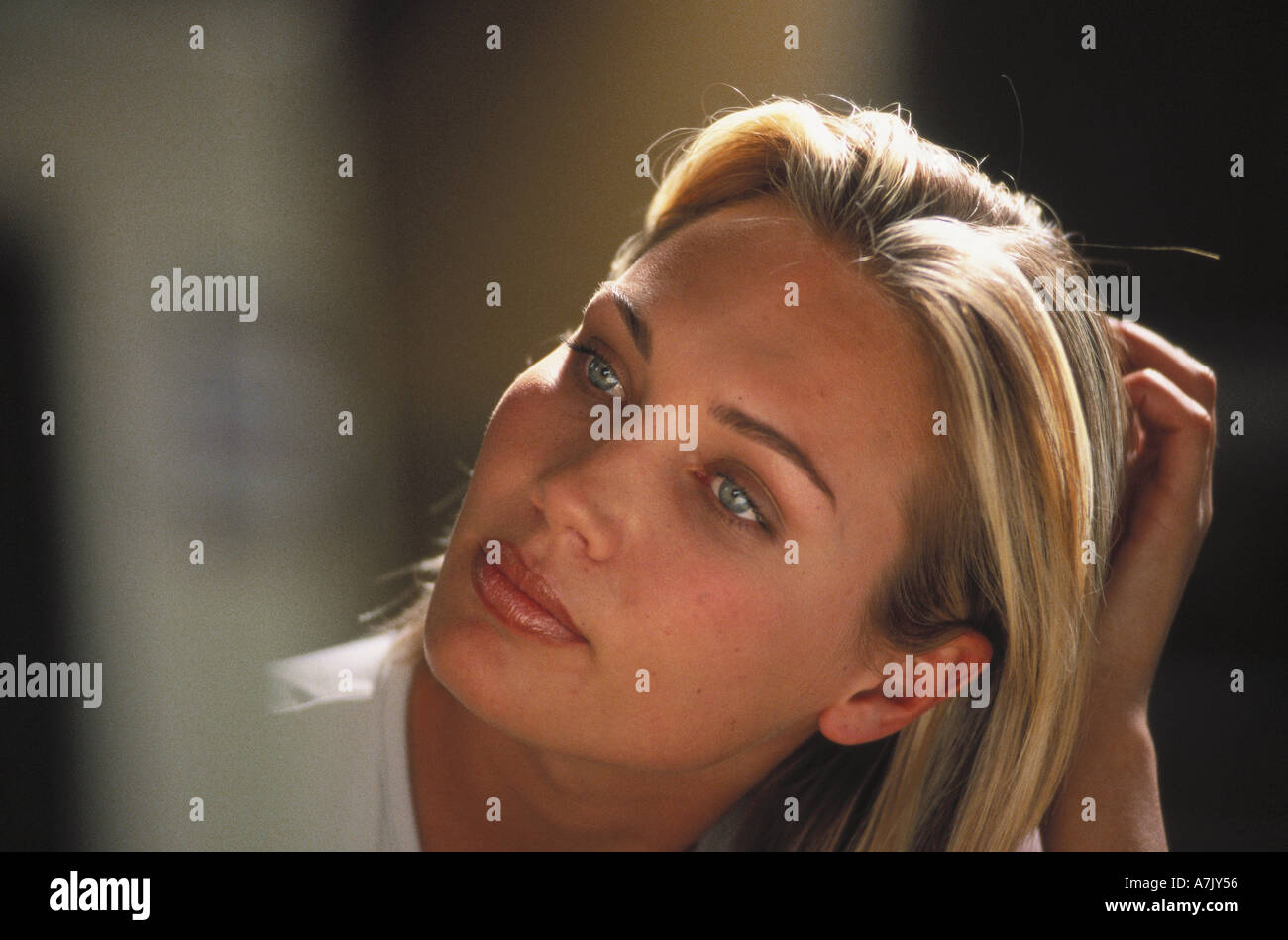 Young woman running her fingers through her hair Stock Photo - Alamy