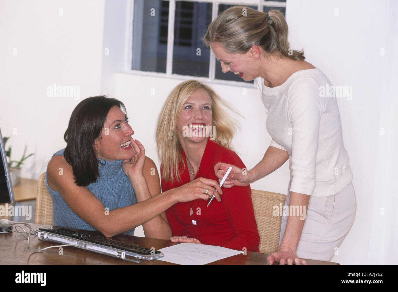 Three young women talking in an office Stock Photo - Alamy
