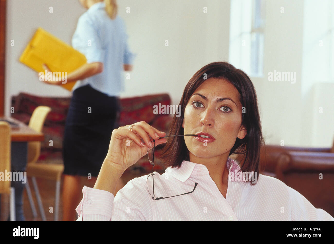 Portrait of a businesswoman biting the shaft of her eyeglasses Stock ...
