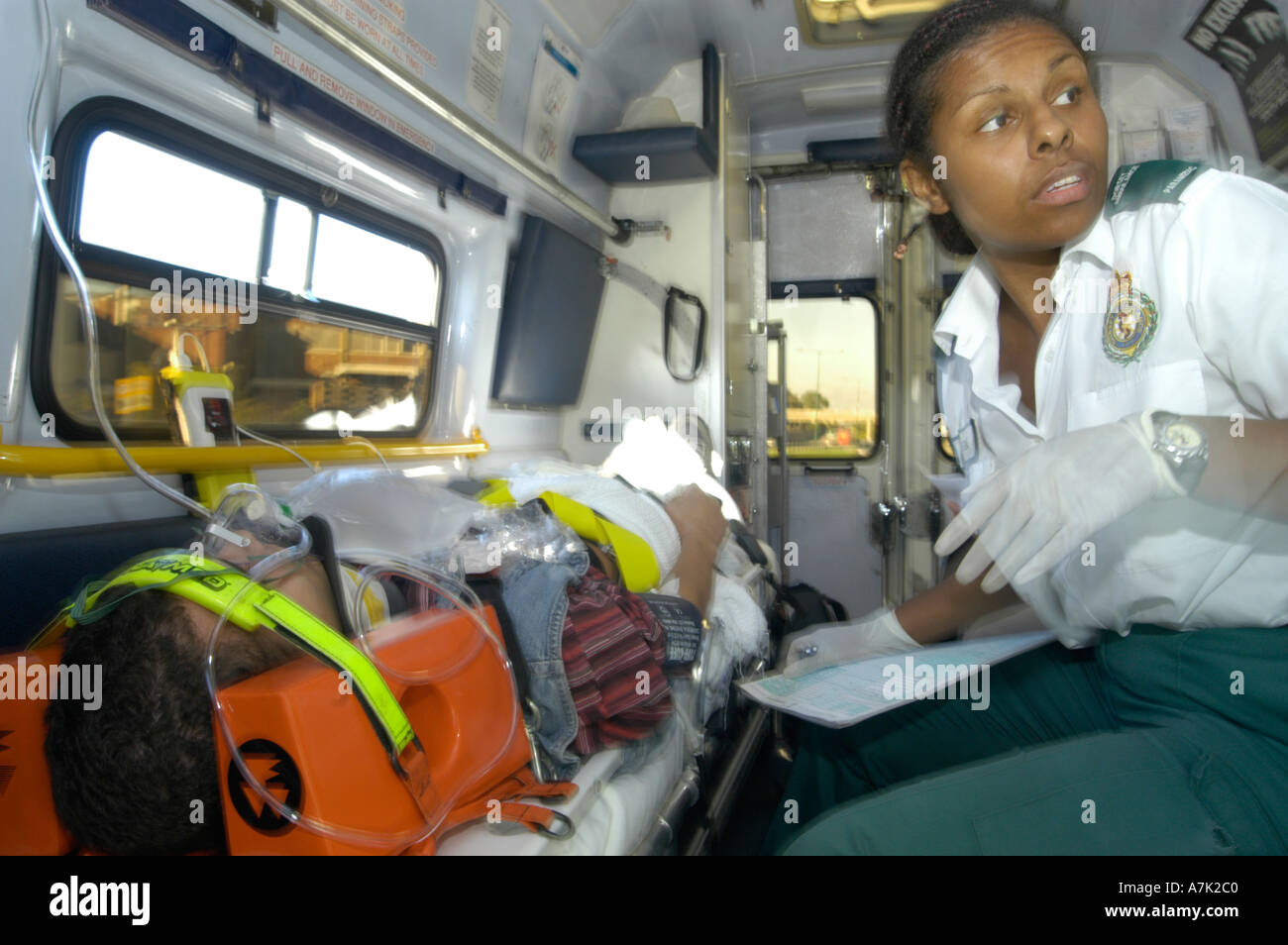 A british female paramedic treating a patient in the back of an ...