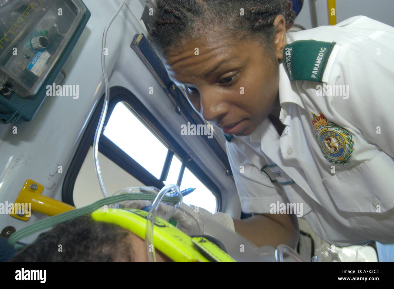 A british female paramedic treating a patient in the back of an ...