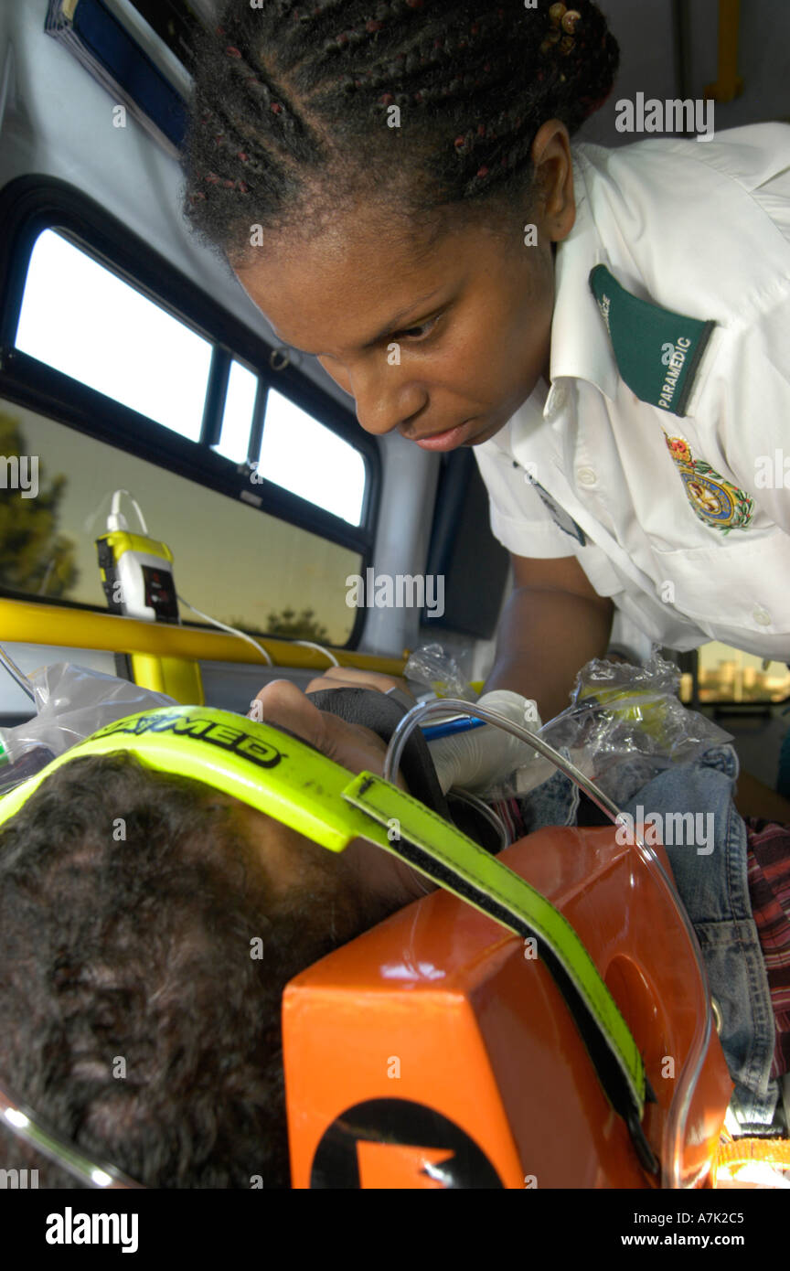 A british female paramedic treating a patient in the back of an ...