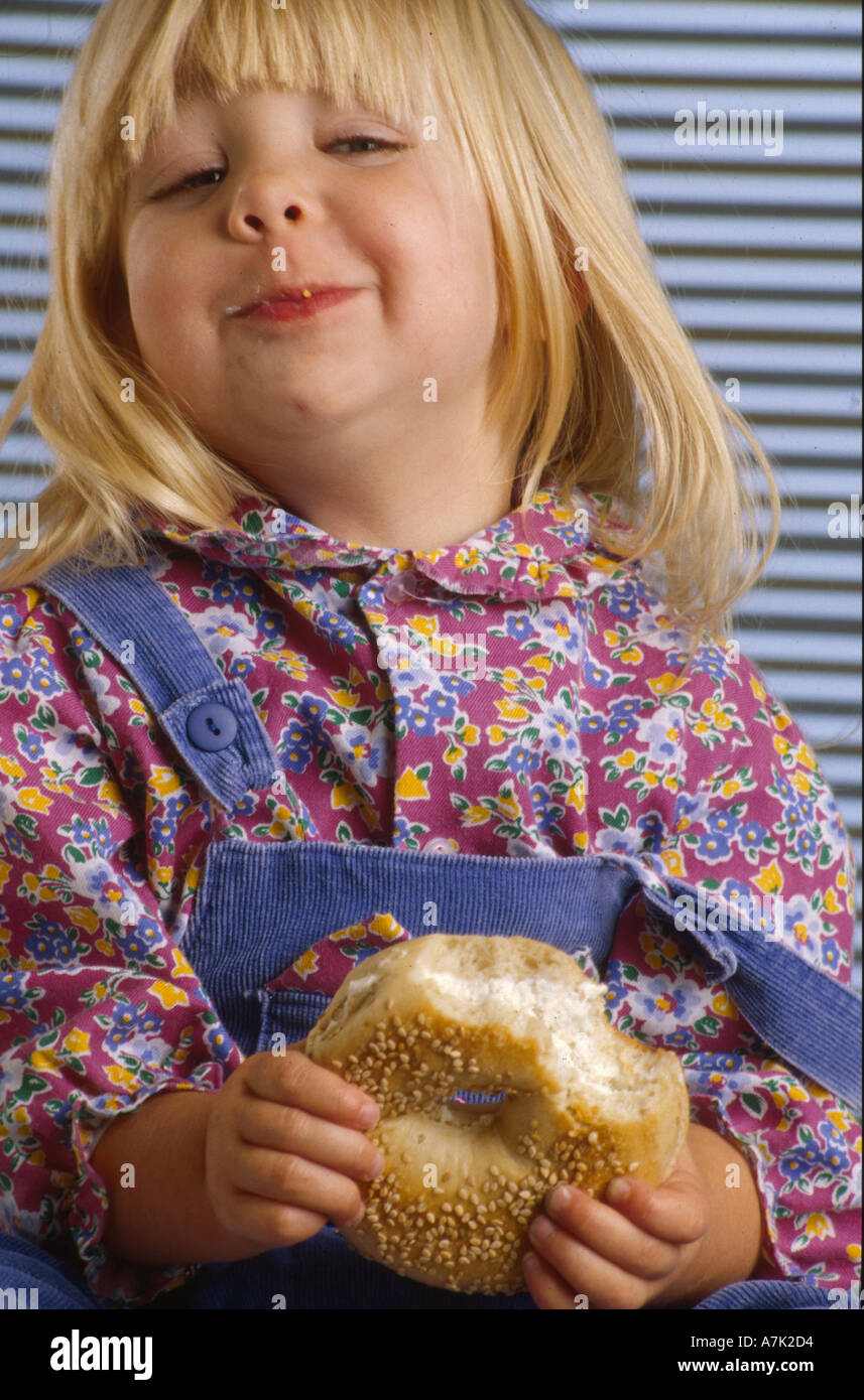Little girl with grinning with bagel Stock Photo - Alamy