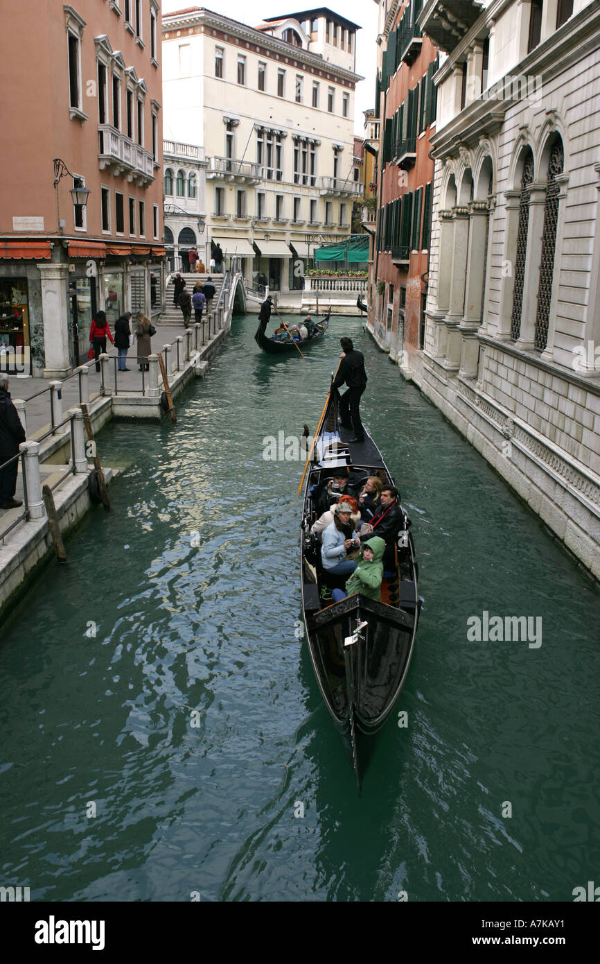 Tourists enjoy a traditional boat trip ride in a Venetian Gondola on a ...