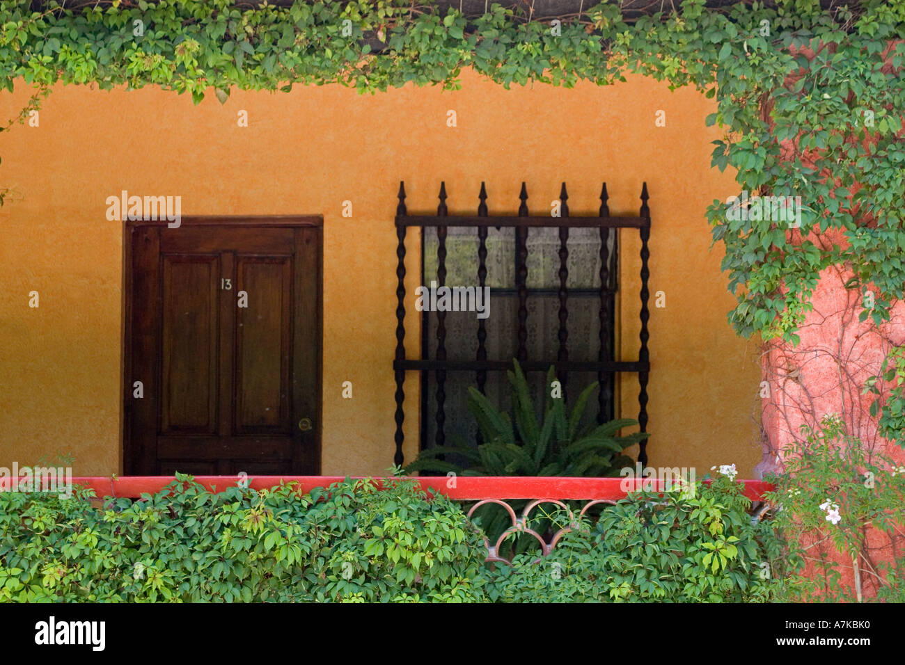 Wrought iron window grate and wooden door create the Mexican style of ...