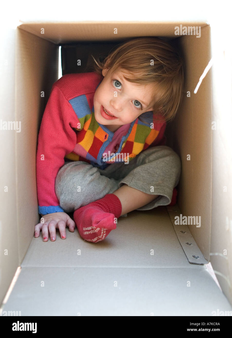 A young 4 year old child in a box Stock Photo - Alamy