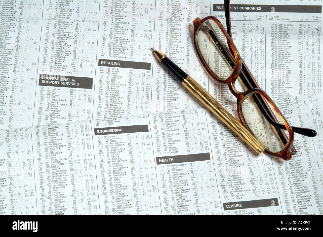 checking list of stocks and shares markets in detail on newspaper page ...