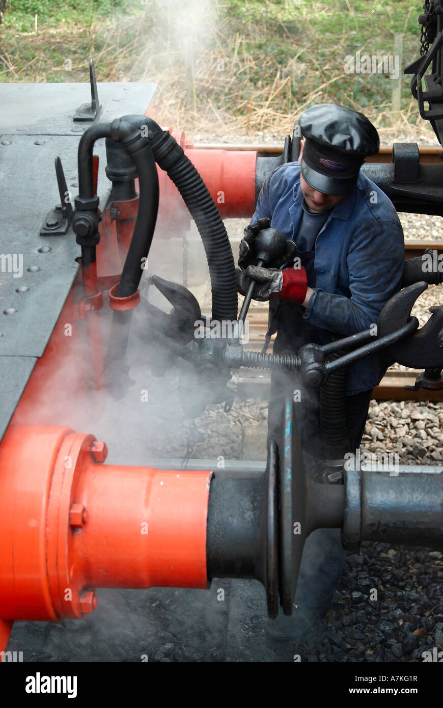 Fireman coupling up a steam locomotive to its train, Holt station ...