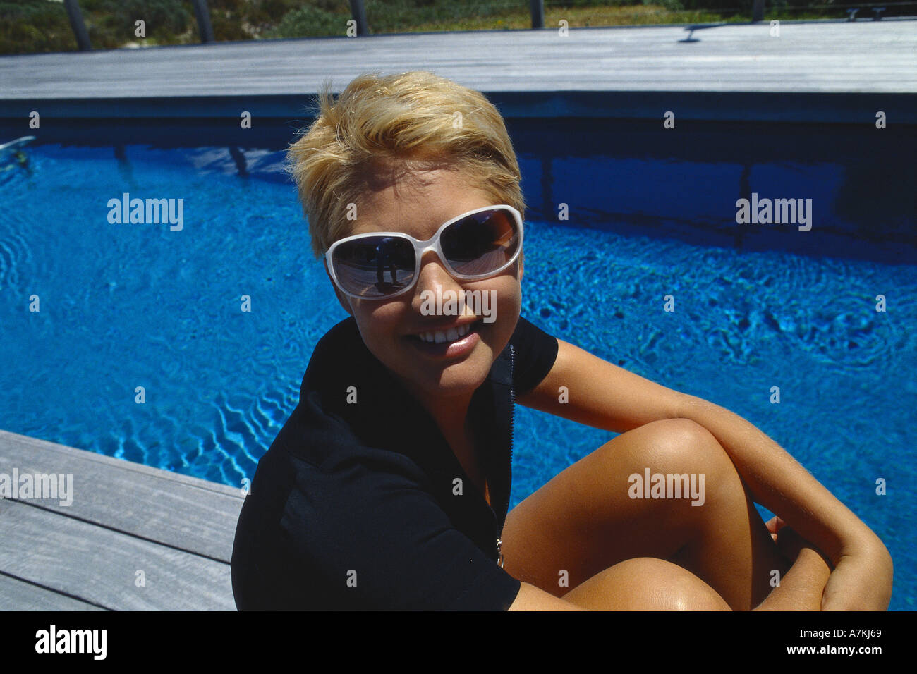 Sitting beside a swimming pool hi-res stock photography and images - Alamy