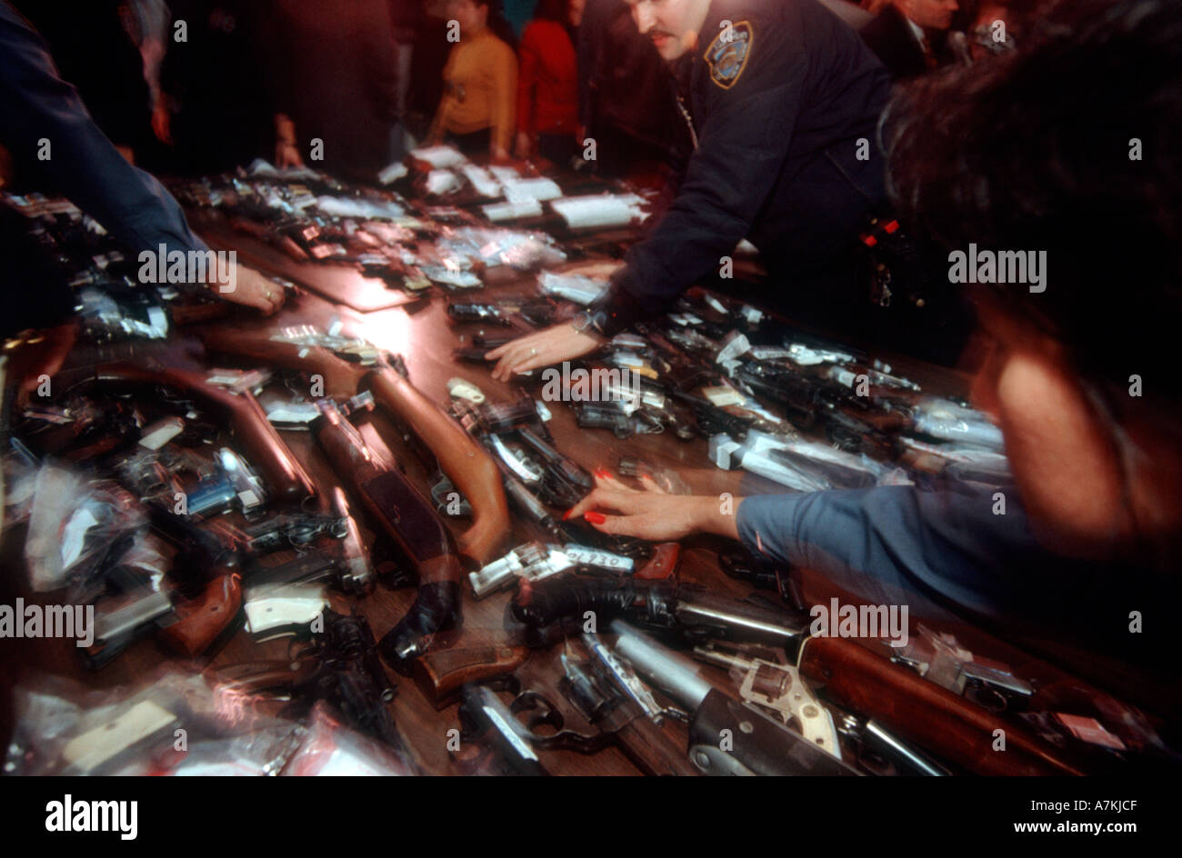 NYPD officers adjust display of weapons turned in under the Toys for ...