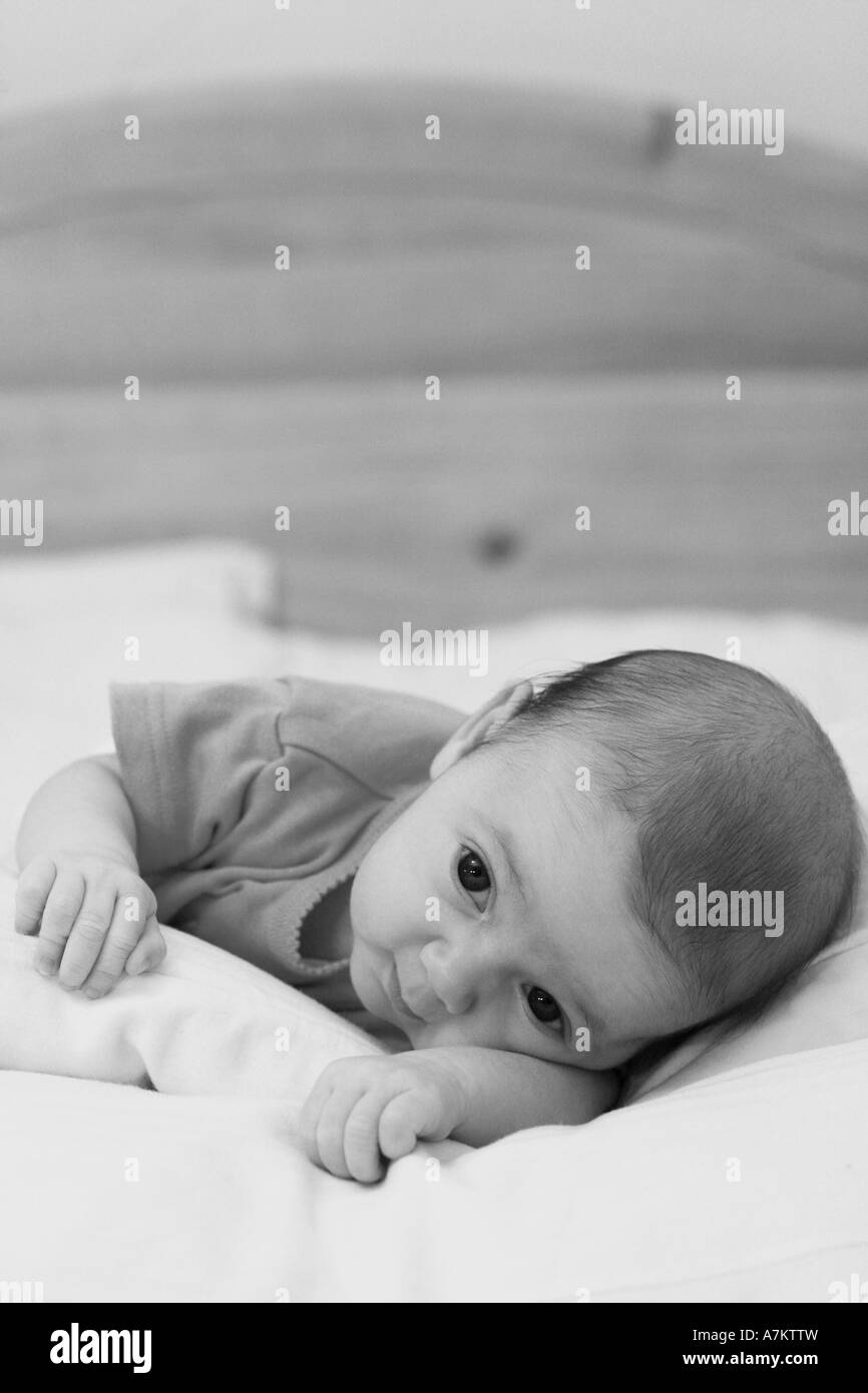 Cute adorable newborn baby with gorgeous big eyes rolls around on ...