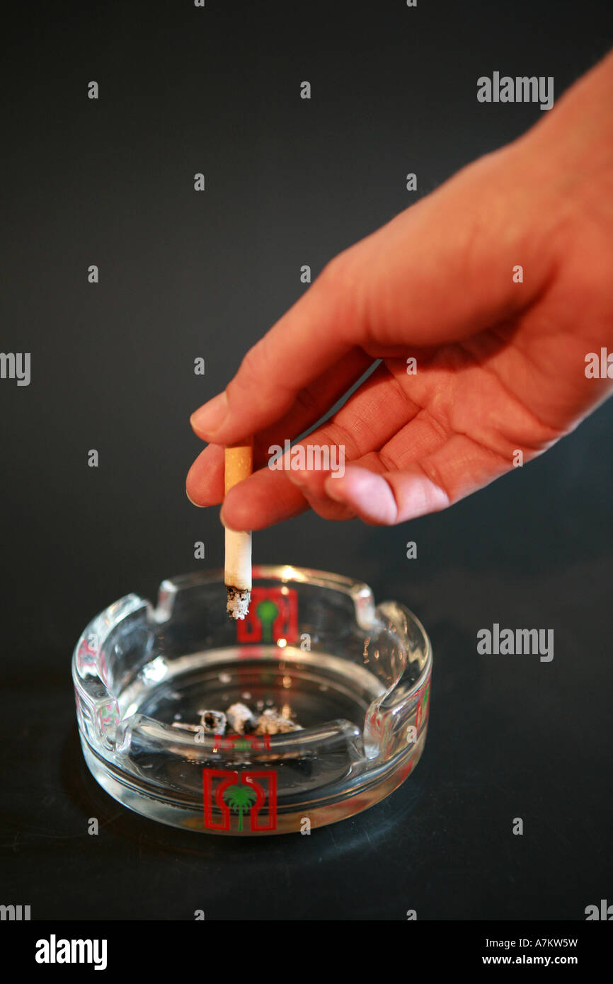 A smoked cigarette is stubbed out and extinguished by a quitting smoker ...