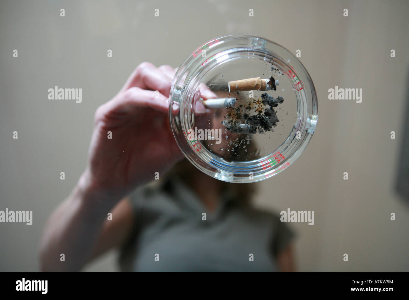 Smoker puts out and extinguishes a finished smoked cigarette into a ...
