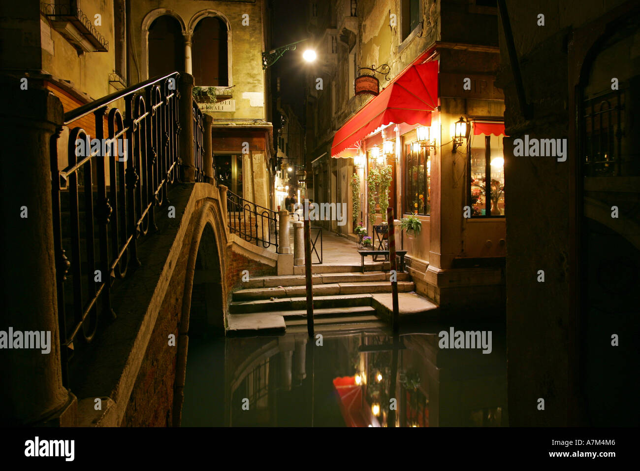 Night view of illuminated Venetian restaurant next to typical backwater ...
