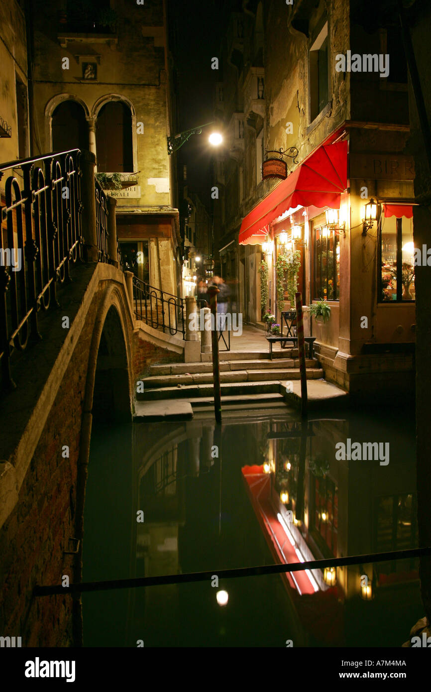 Night view of illuminated Venetian restaurant next to typical backwater ...