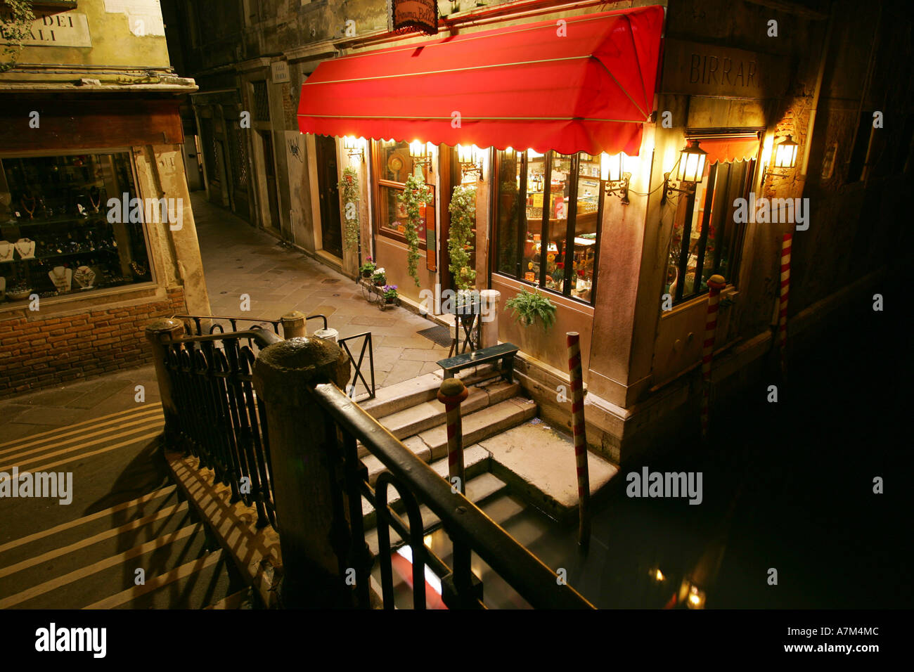 Night view of illuminated Venetian restaurant next to typical backwater ...