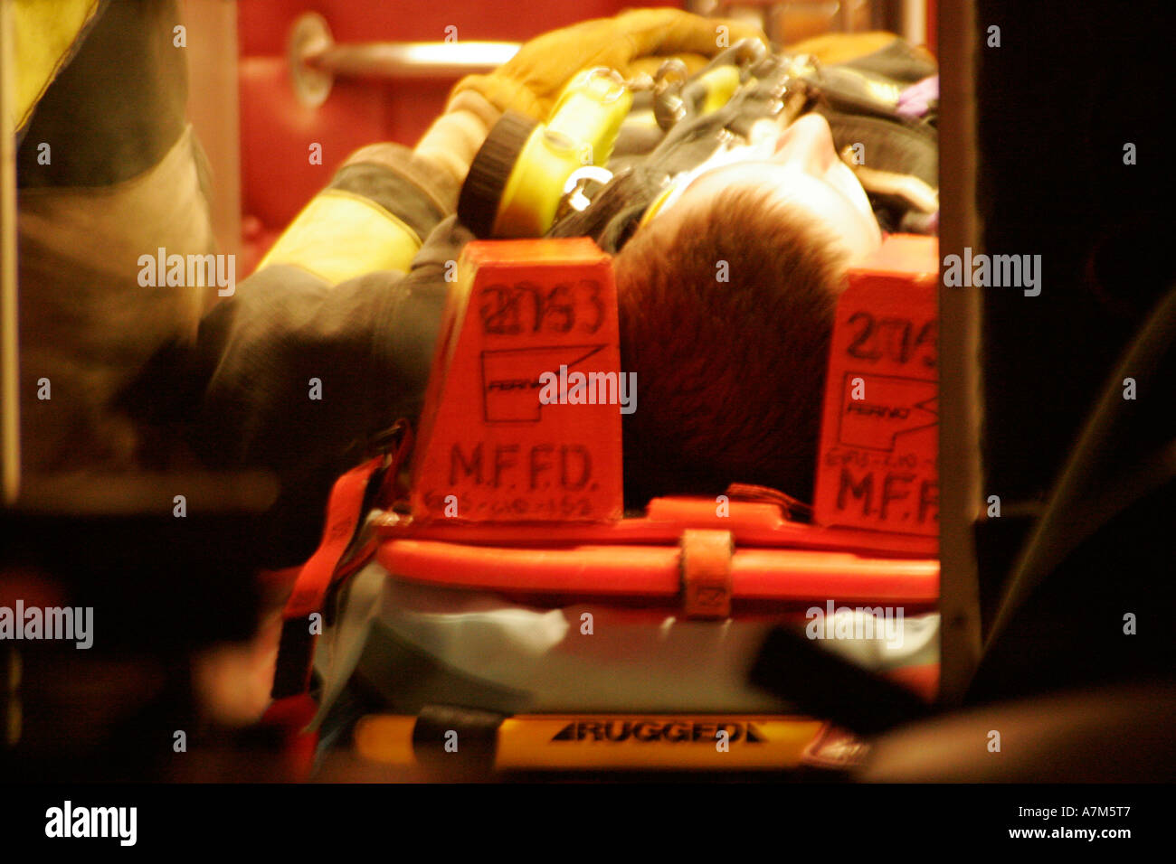 A fire fighter victim in structure collapse in an ambulance being ...