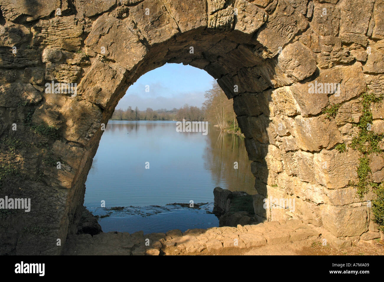 Arched bridge over waterfall at lake in Buckinghamshire England UK ...