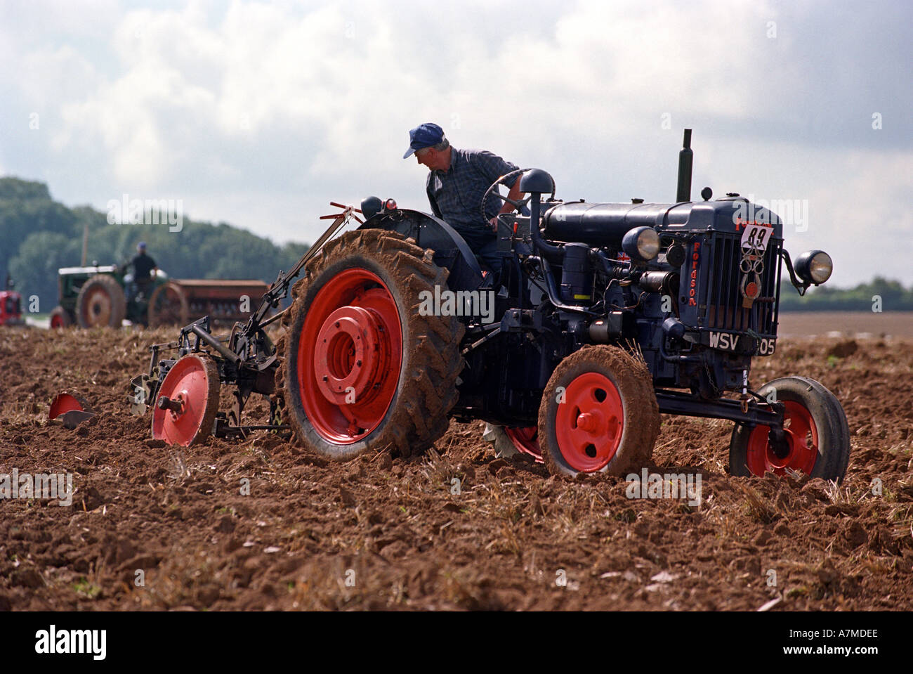 An old fashioned vintage working tractor ploughing a field Stock Photo ...