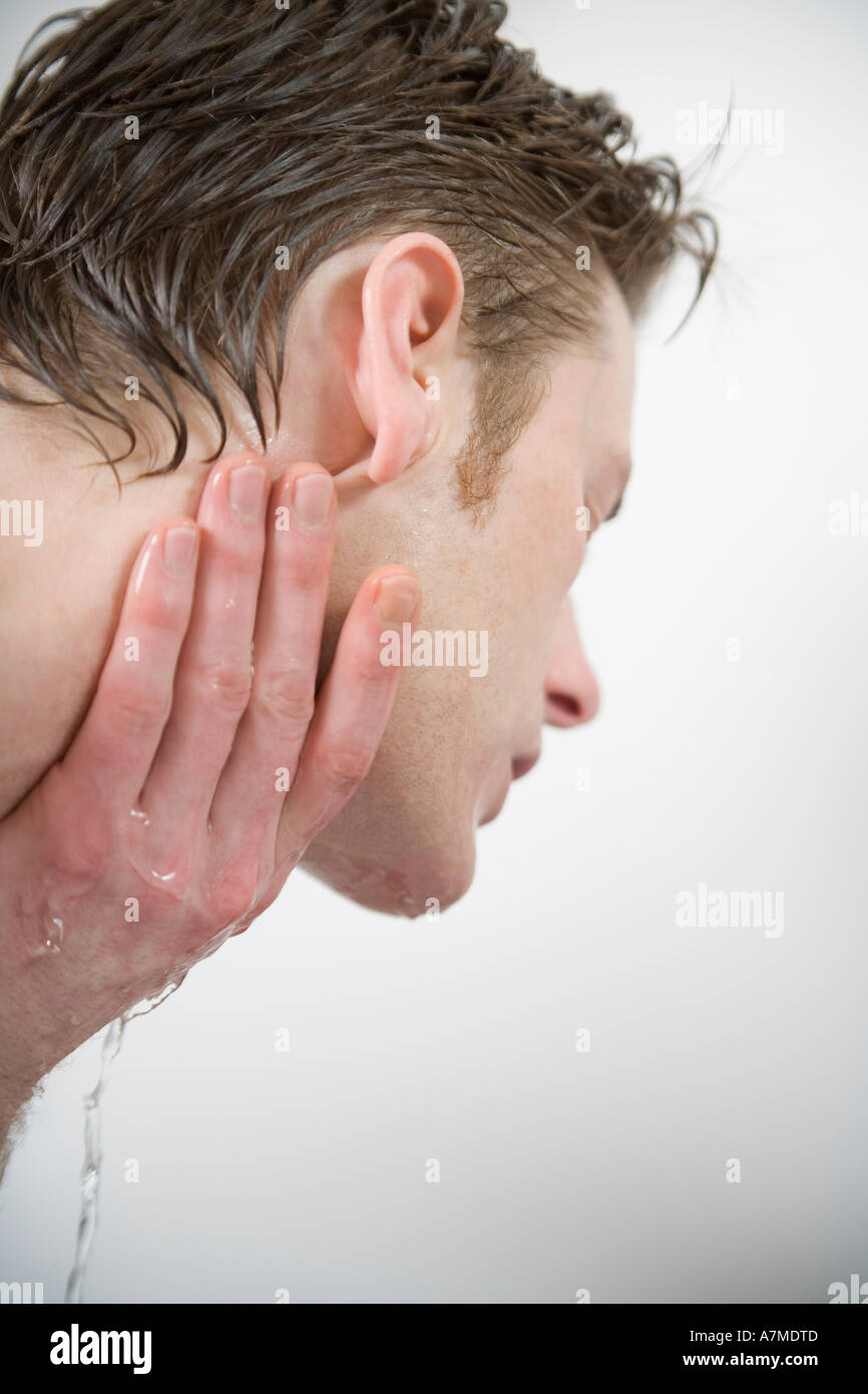 Man splashing water on his face and neck Stock Photo - Alamy
