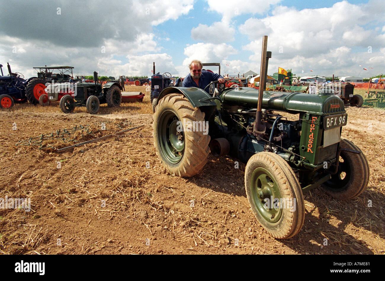 An old fashioned vintage working tractor ploughing a field Stock Photo ...