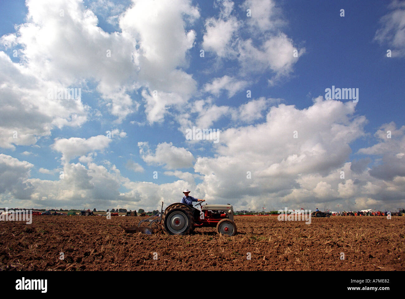 An old fashioned vintage working tractor ploughing a field Stock Photo ...