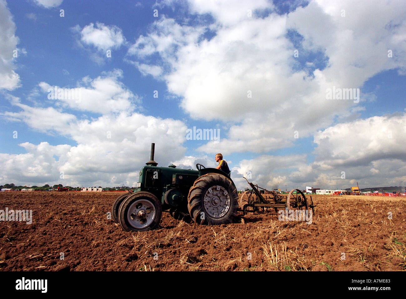 An old fashioned vintage working tractor ploughing a field Stock Photo ...