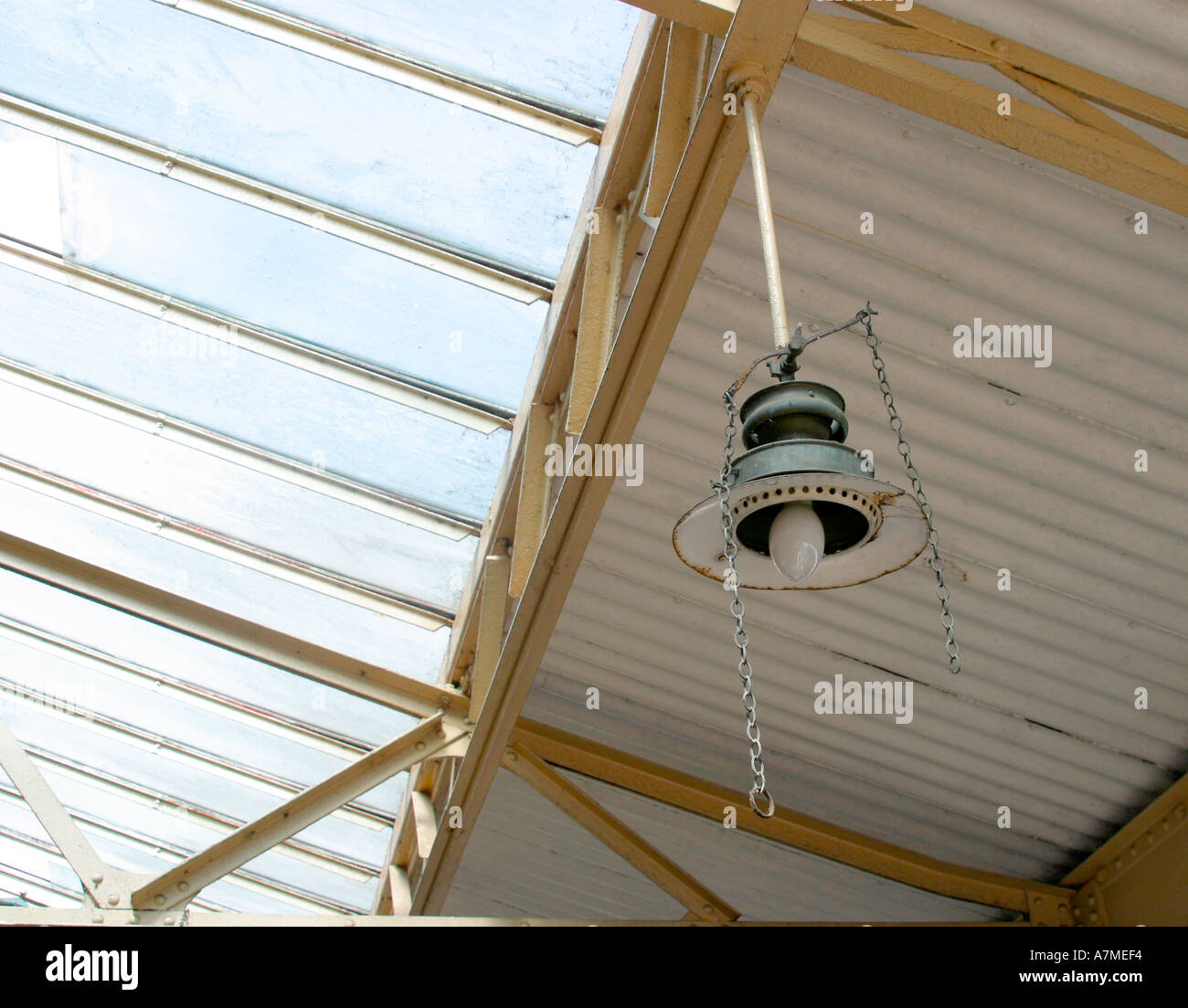 Old fashioned style light fitting hanging from station roof Stock Photo ...