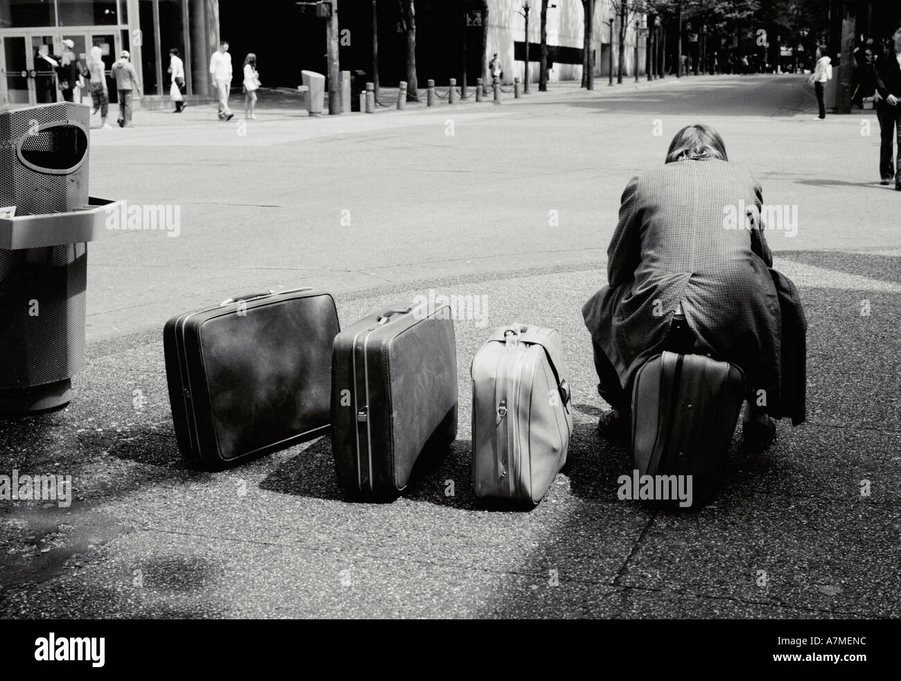 Man waiting on street corner with luggage Stock Photo - Alamy