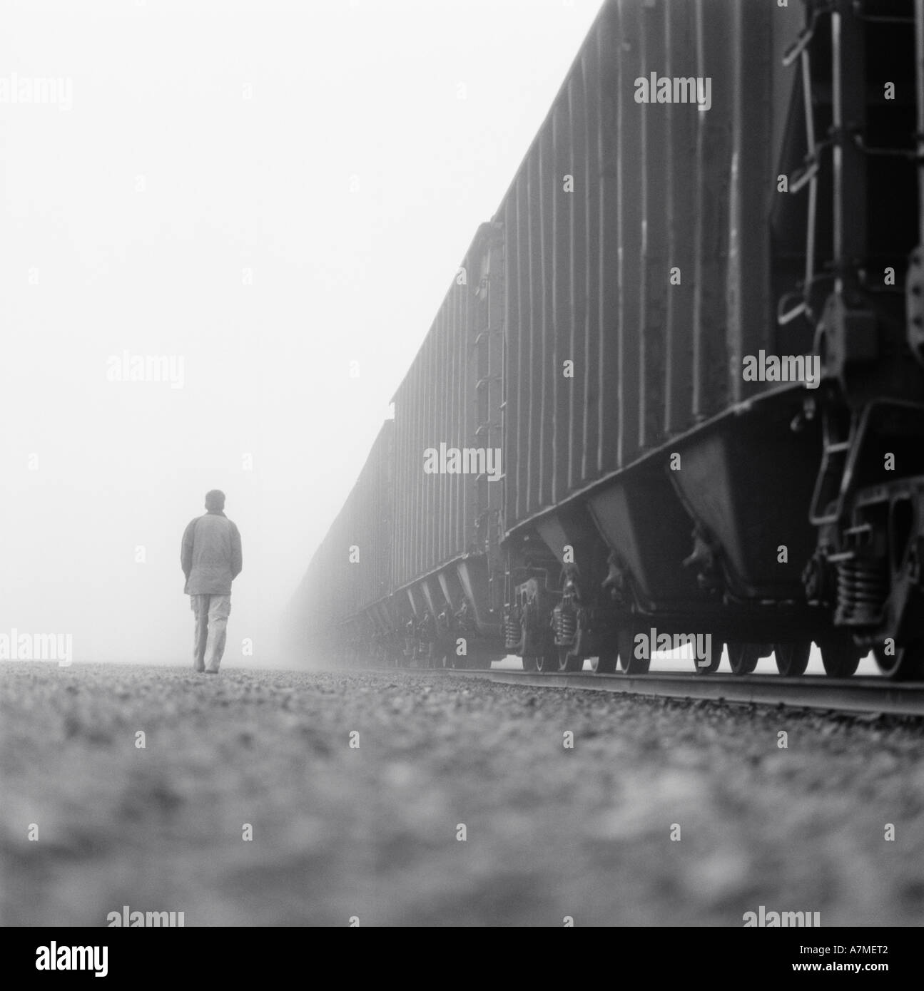 Man walking next to freight train Stock Photo - Alamy