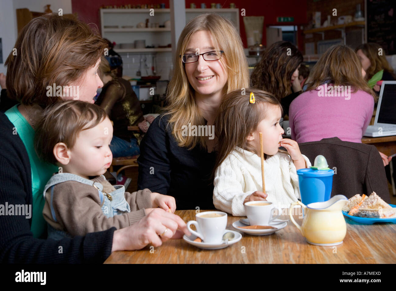 Two mother's in a cafe with children sitting on their laps Stock Photo ...