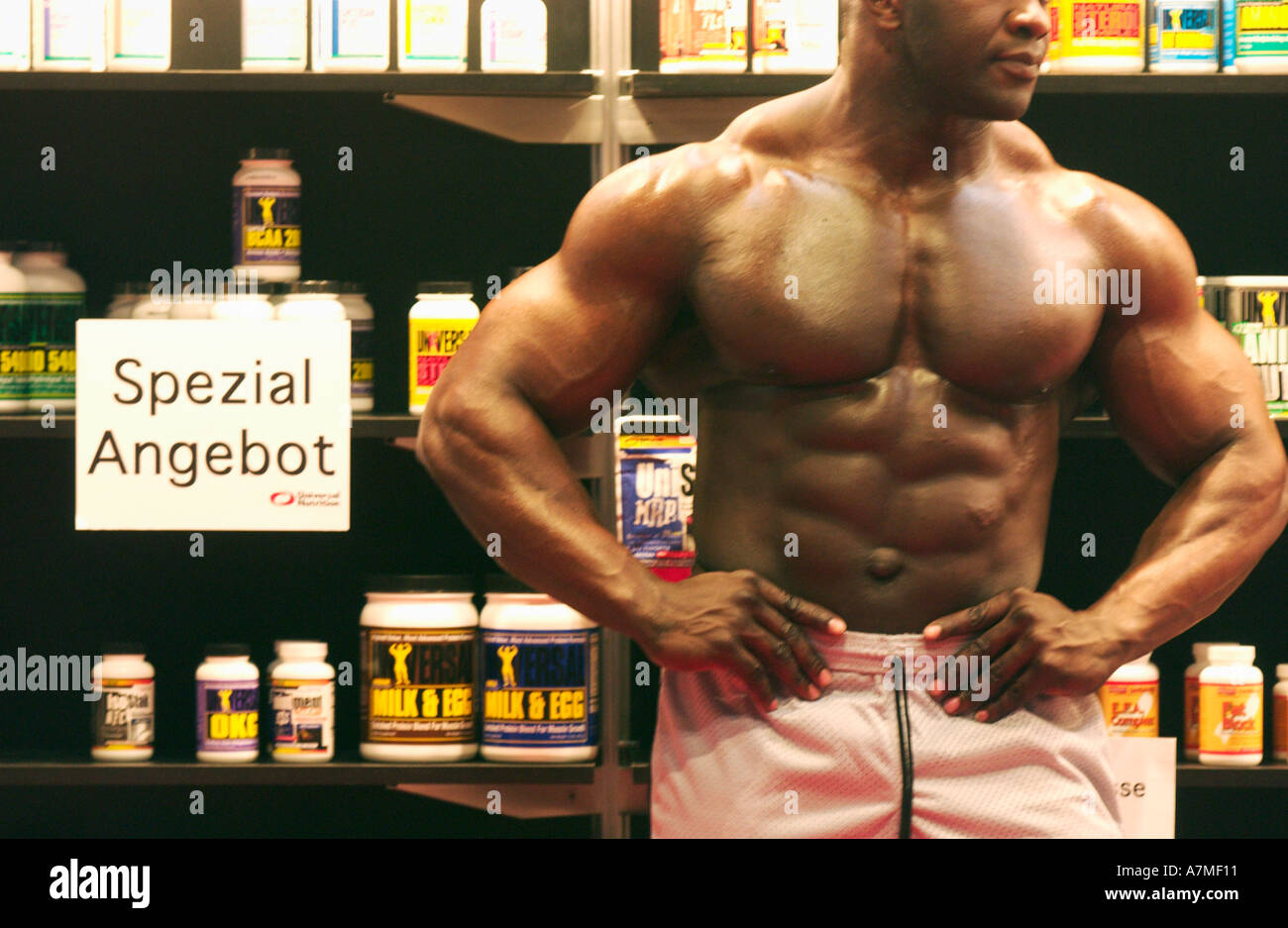 detail of a male bodybuilder in front of a nutrition shelf with special ...