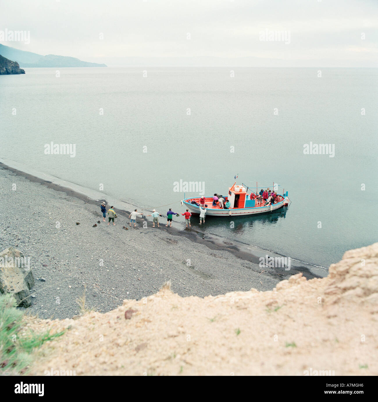 A group of people boarding a brightly painted boat Stock Photo - Alamy