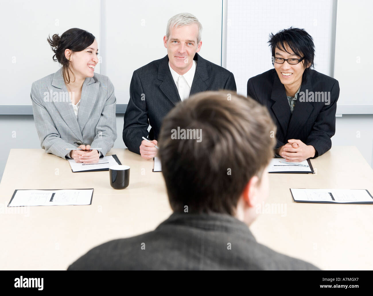 Three people interviewing a candidate in an office Stock Photo - Alamy