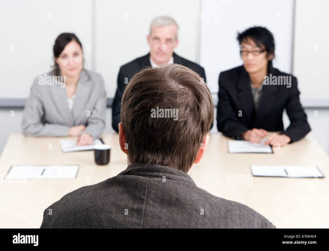 A man being interviewed by three people Stock Photo - Alamy
