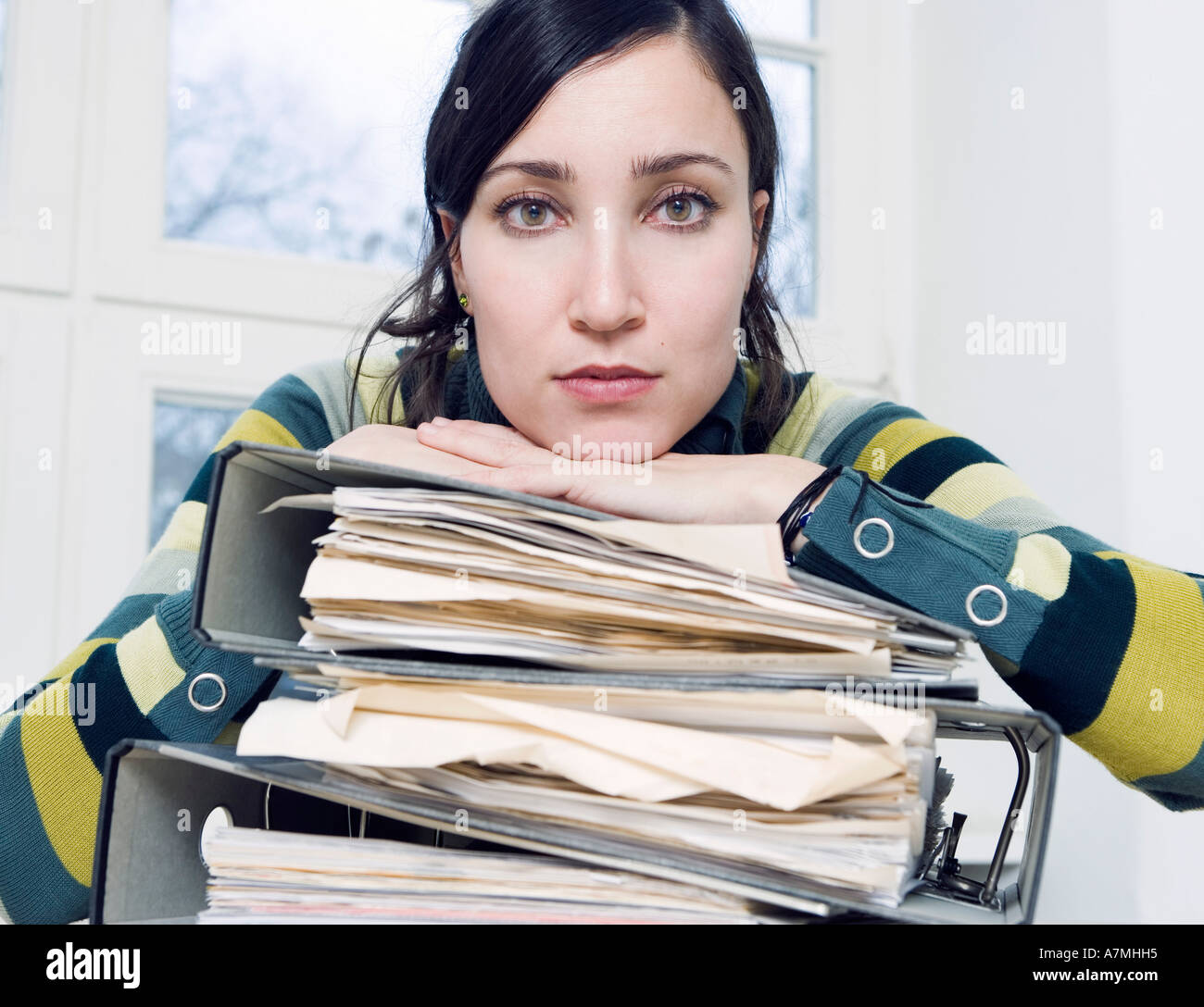 A woman resting her head on a stack of binders Stock Photo - Alamy