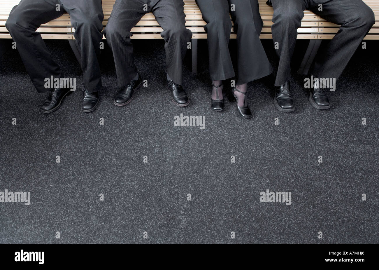 Four businesspeople sitting on a bench Stock Photo - Alamy