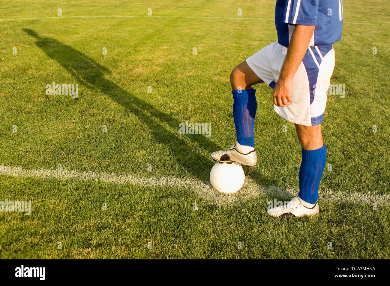 A soccer player with his foot on the ball Stock Photo - Alamy