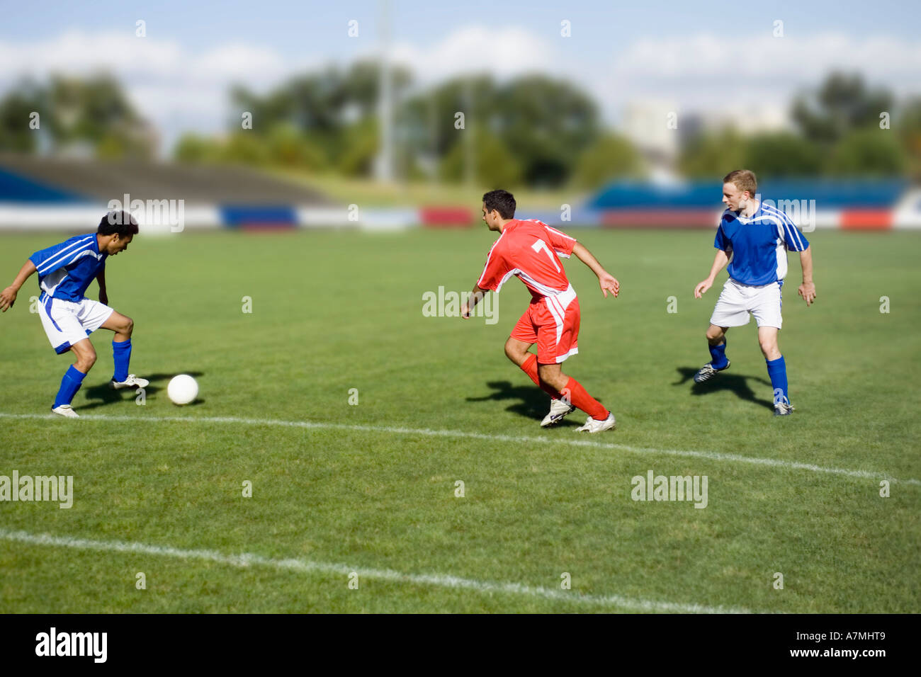 Three people playing soccer Stock Photo - Alamy