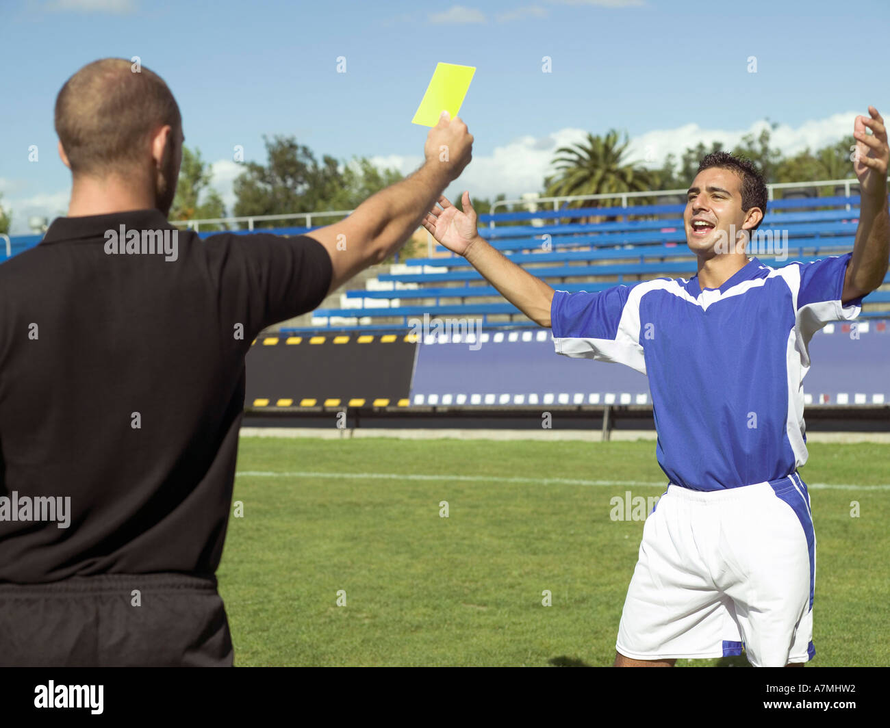 A referee giving a soccer player a yellow card Stock Photo - Alamy