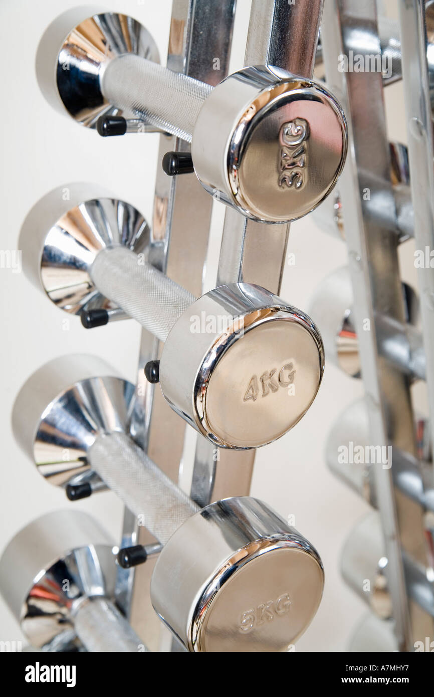 Silver dumbbells on rack Stock Photo - Alamy