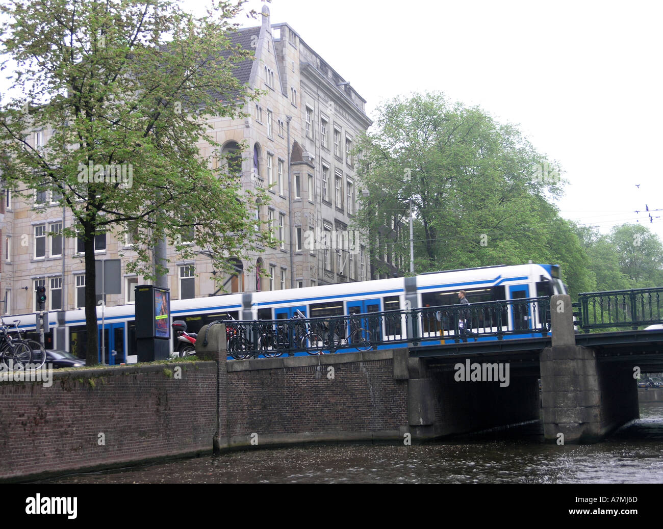 Tram crossing canal bridge in amsterdam Stock Photo - Alamy